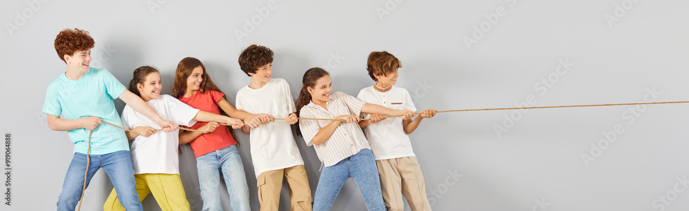 Group of happy teenage friends playing tug of war and having fun ...