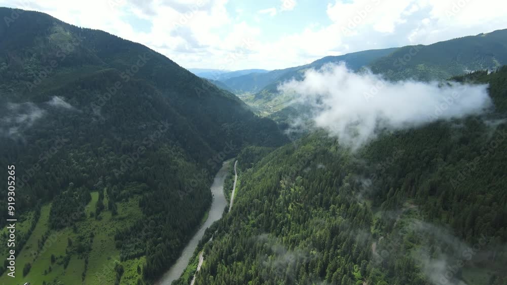 FPV drone footage flying through clouds over a lush green landscape ...