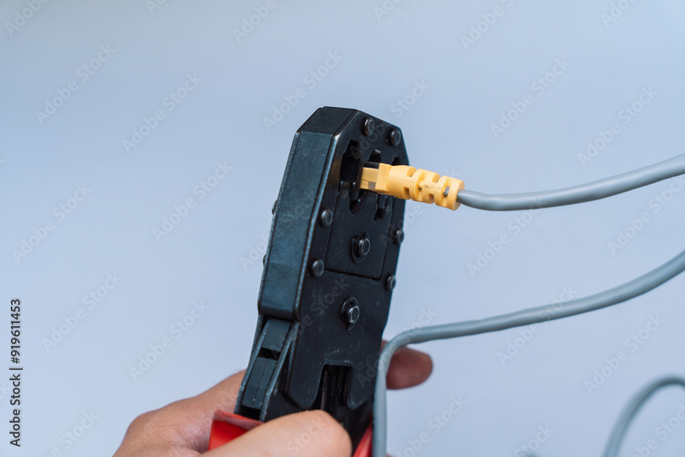 Specialist crimps connector on network cable using crimper. Stock Photo ...