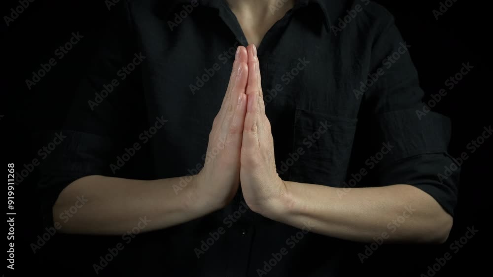 Praying lady hands against black background. A view of victim hands ask ...