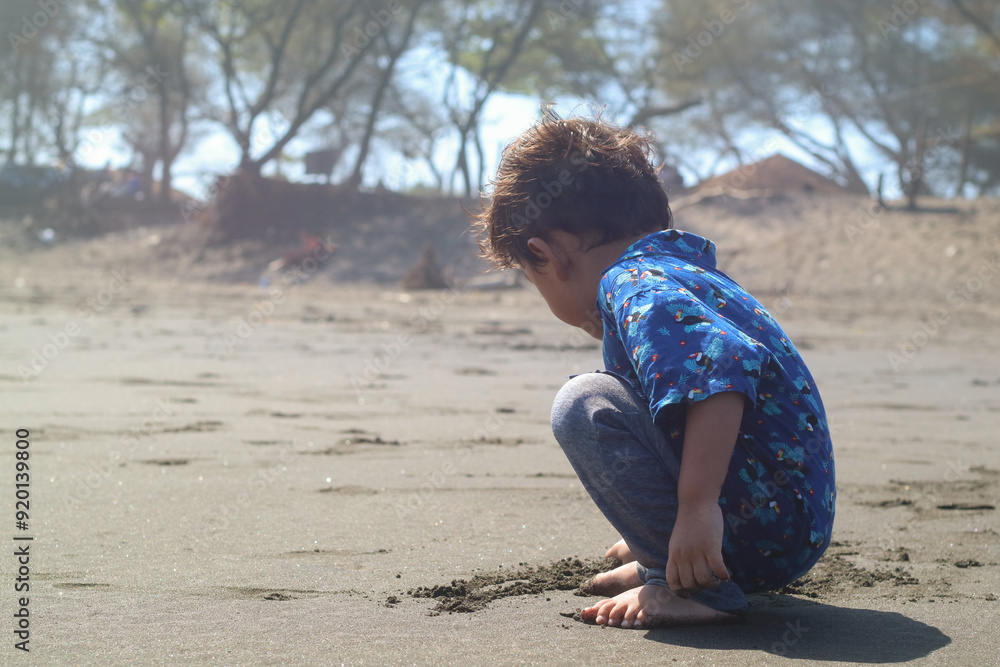 Cute child drawing picture on a sand playing outdoor on summer beach ...