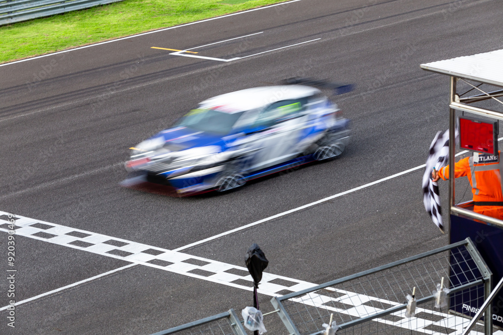 Race car crossing finish line on track and pass checkered race flag, Checkered racing finish ...