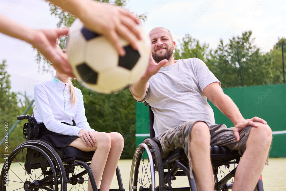 People in wheelchairs actively participating in a sport, sharing a ball ...