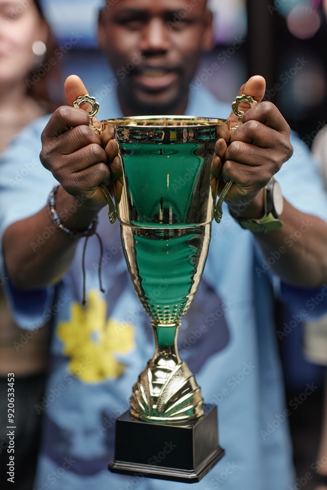 African American man holding green trophy with both hands smiling ...