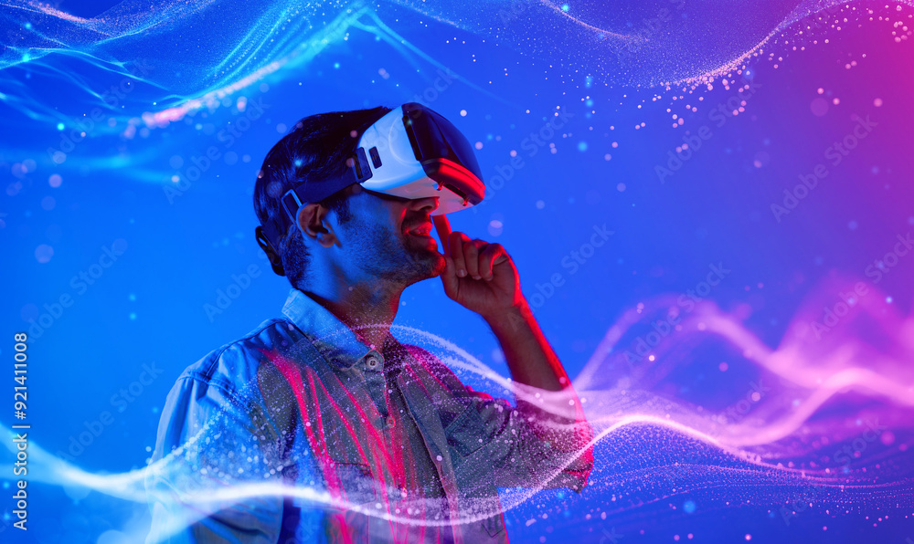 Smart caucasian man wearing VR glasses while standing at neon light ...