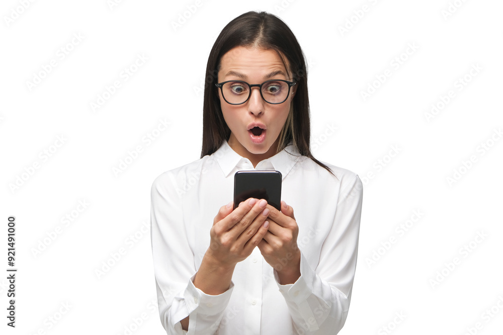 Young woman with shocked face staring at screen of her phone, dressed ...