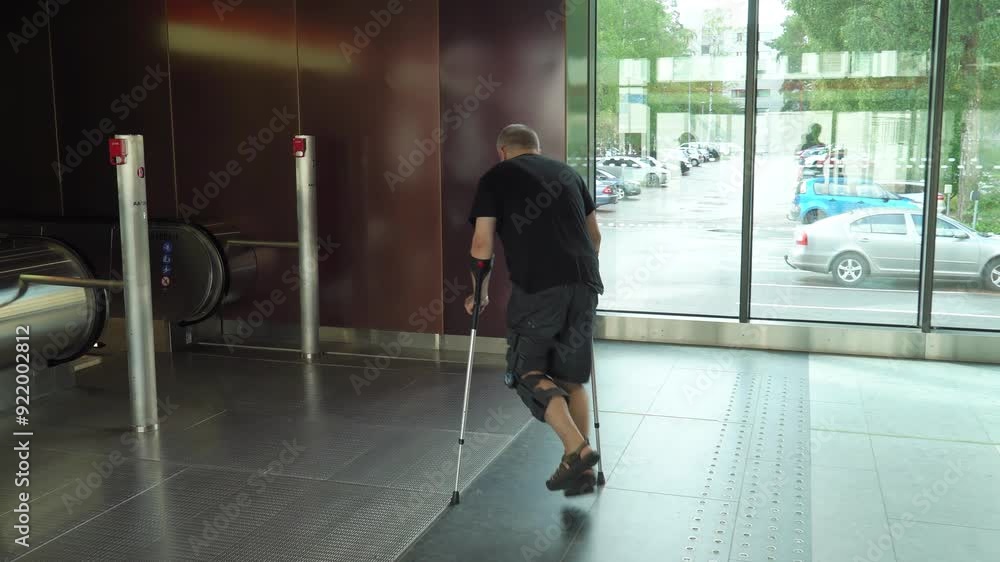 Mature man with bondage, medical splint, knee brace on the leg goes ...