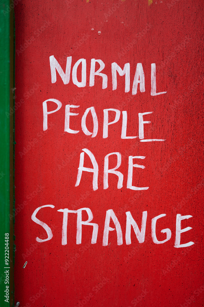 Quirky handwritten message "Normal People Are Strange" on a vibrant red ...