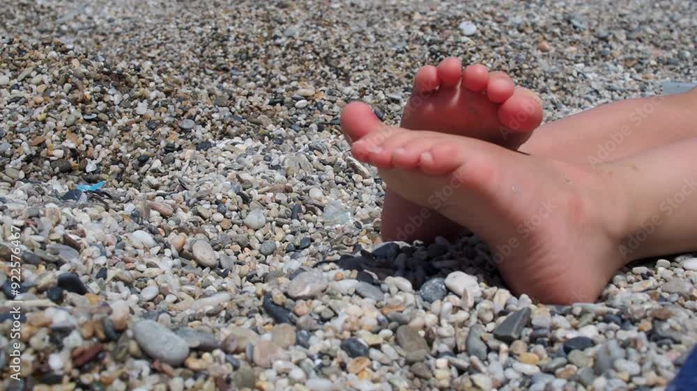 A children bare feet on a pebble beach vídeo do Stock | Adobe Stock