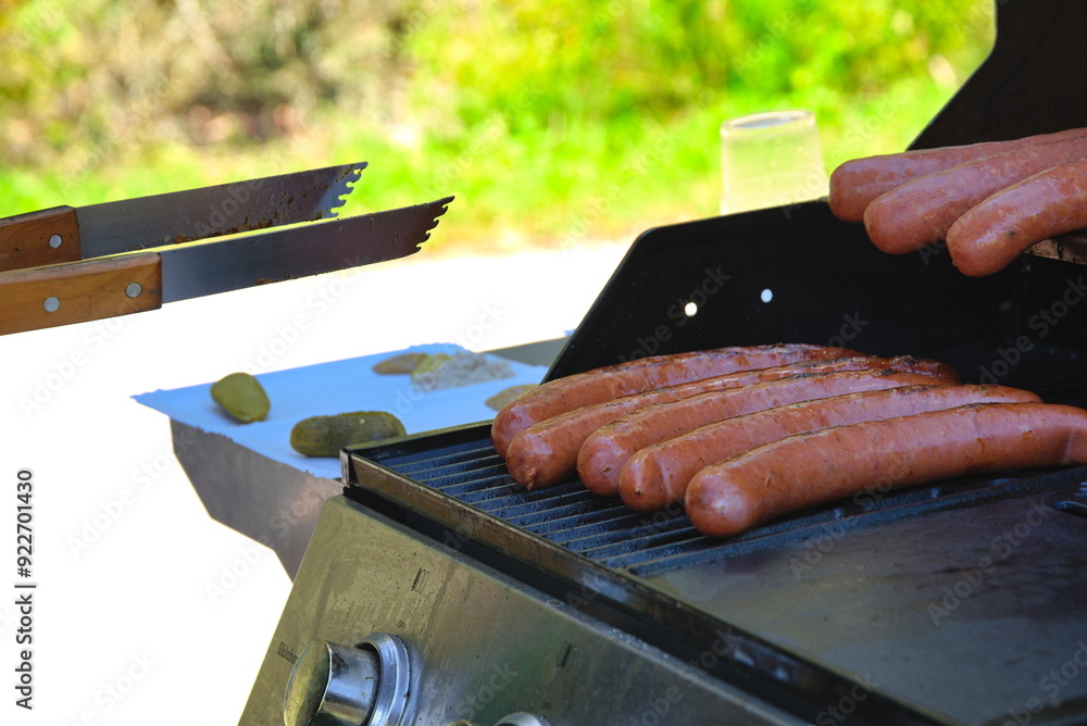 Grillen von Käsekrainer mithilfe einer Grillzange - Grillerei Stock ...