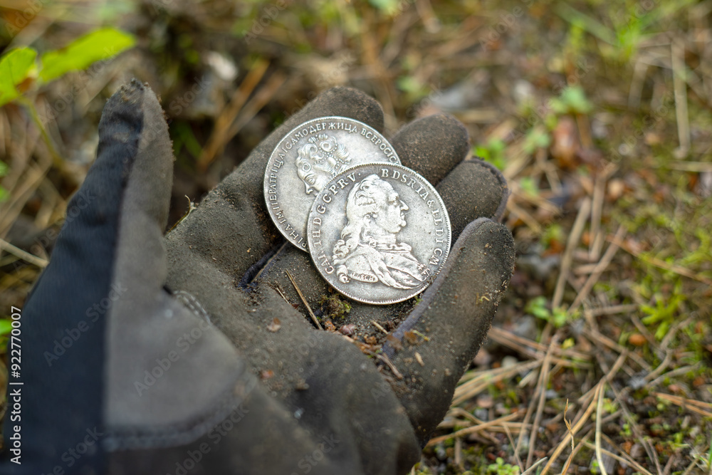 Finding silver coins in the floor.A hand holds coins found in the ...