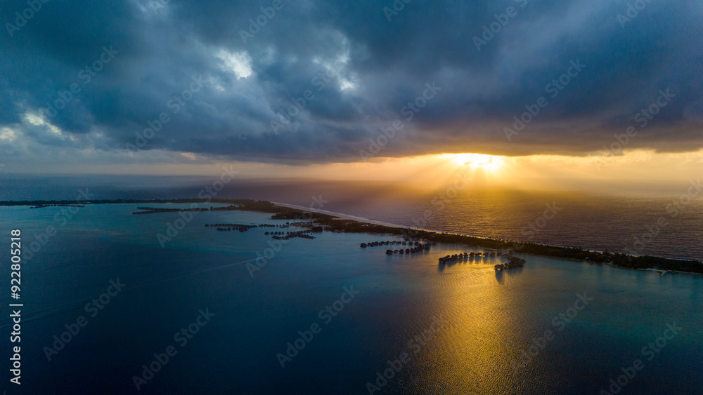 Low clouds loom over tropical island resorts featuring overwater villas ...