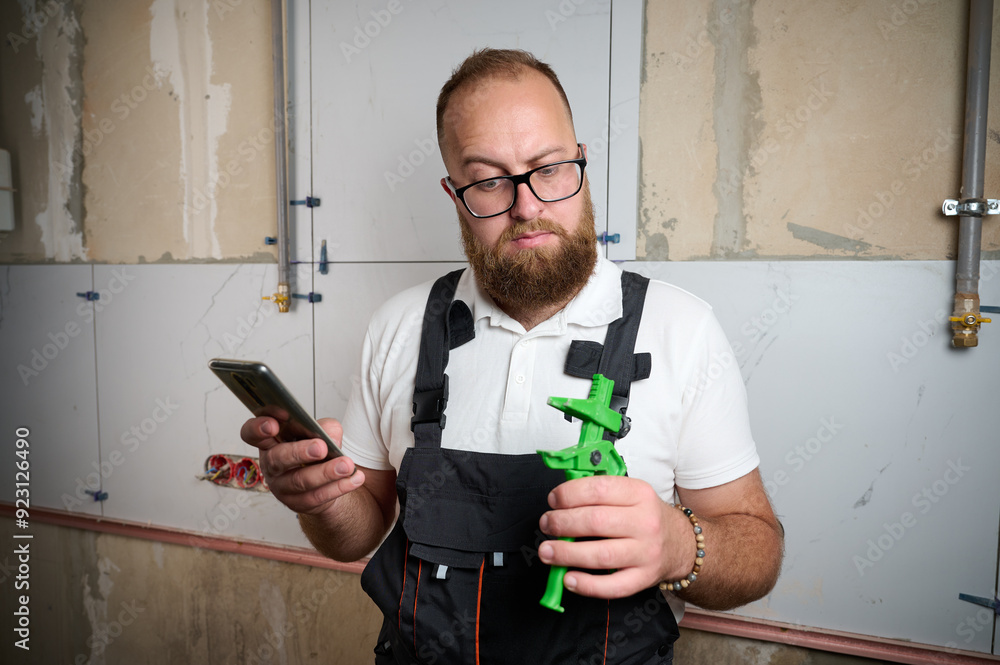 Laying Ceramic Tiles. Tiler placing ceramic wall tile in position over ...