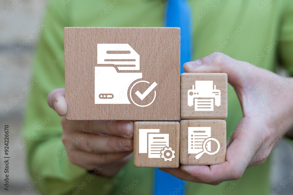 Man holding wooden blocks sees icon: directory with file and check mark ...