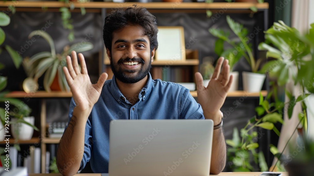 A cheerful man from India who is deaf sits at a desk using a computer ...