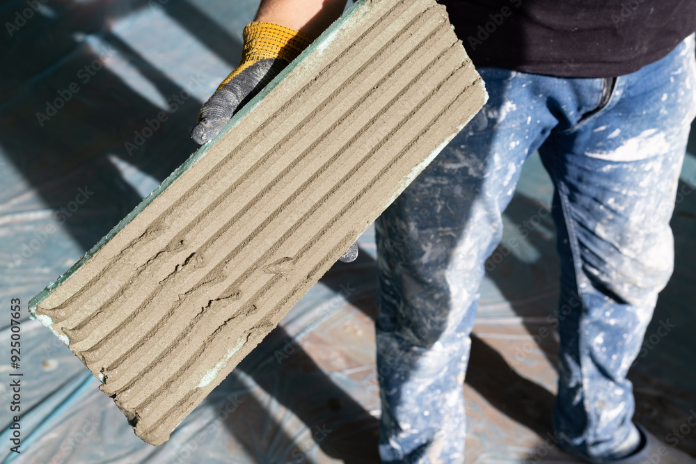 Construction worker bricklayer holds xps (Extruded Polystyrene) plate ...