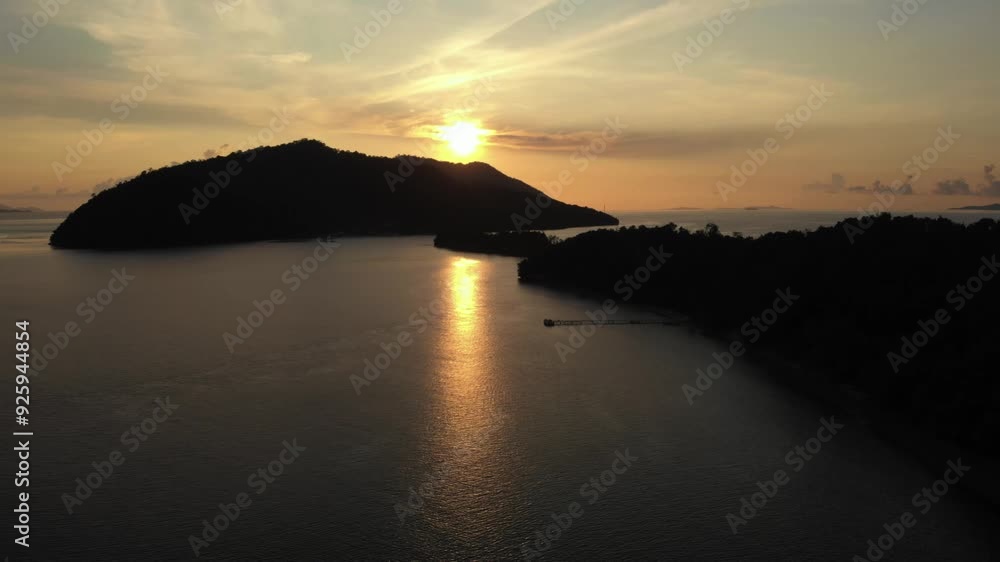 A stunning sunset over Kri Island in Raja Ampat, Idonesia, captured ...