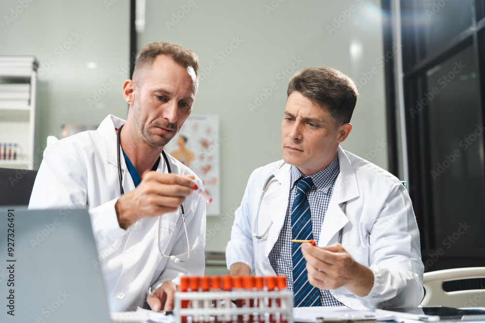 Doctor taking a blood sample tube from a rack with machines of analysis ...
