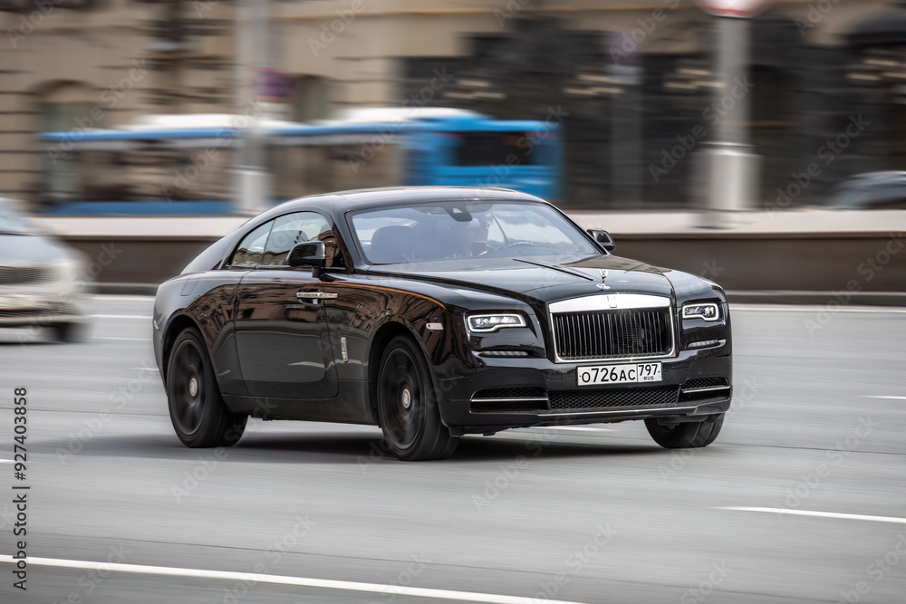 car Rolls Royce Wraith driving along the street in city with blurred ...
