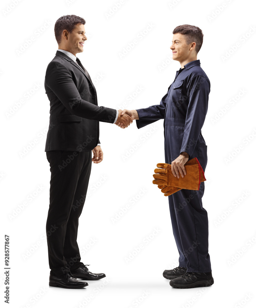 Full length profile shot of a handshake between a working class young ...