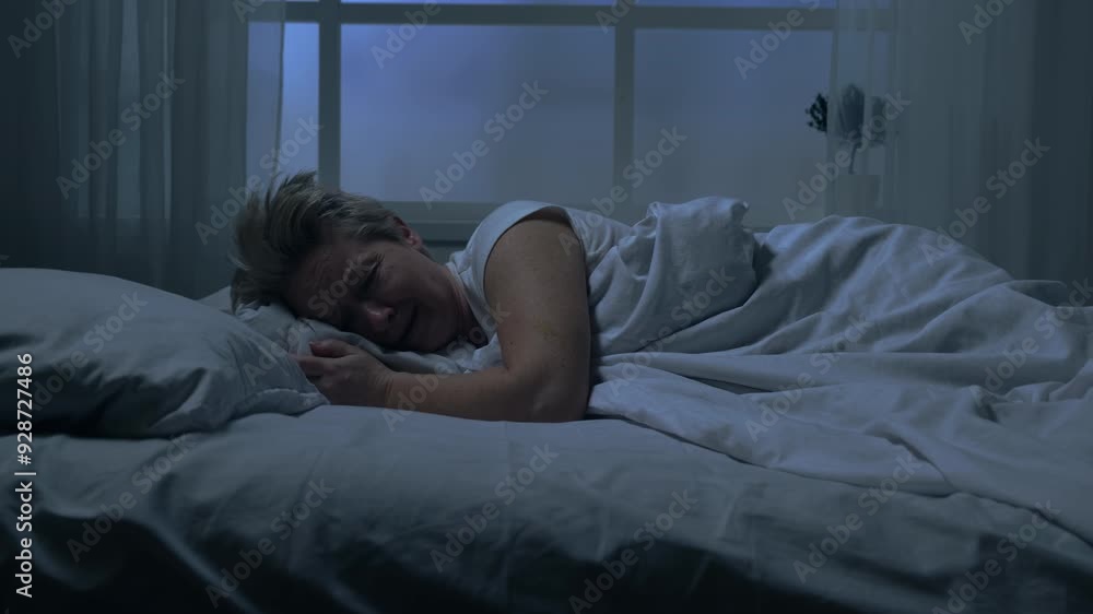 Sad woman crying while lying in bed in bedroom at night, loneliness ...