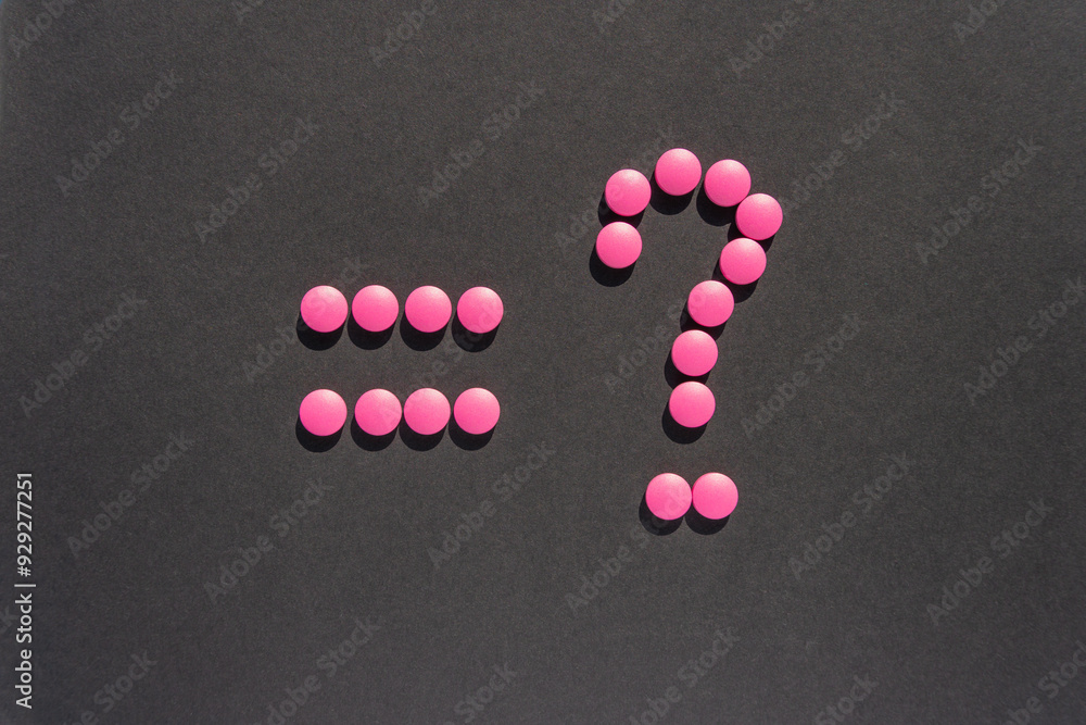 Round medicine pink tablets on dark background in the form sign ...