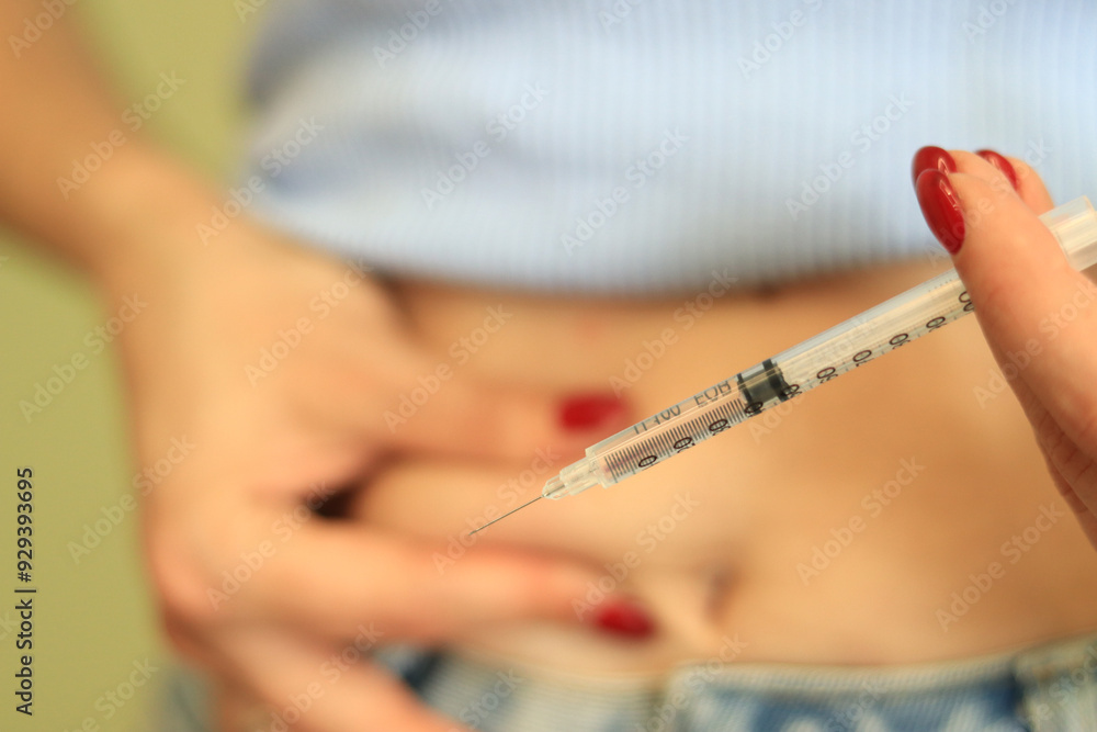 Insulin syringe. A woman with a syringe is about to inject herself with ...