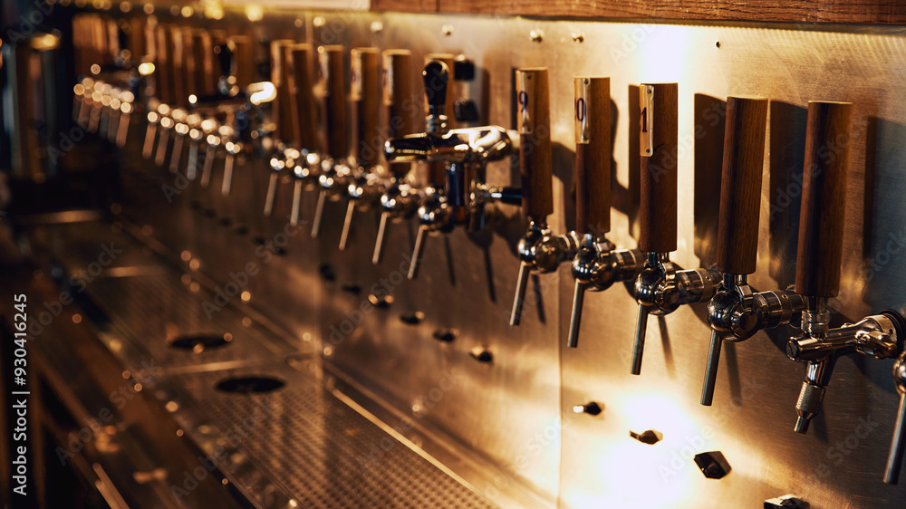 Row of shiny beer taps with numbered wooden handles, mounted on ...