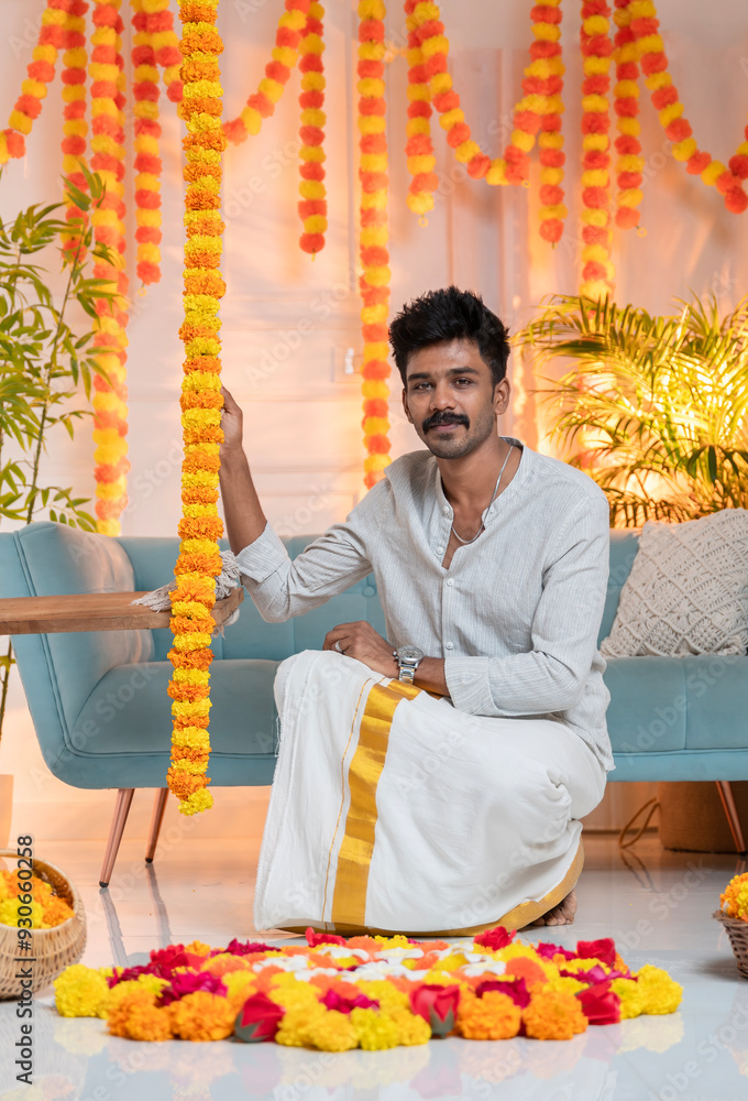 South Indian man sitting near Onam pookalam, 2024 Happy Onam photo ...
