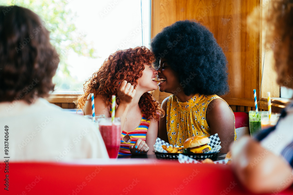 Multiethnic group of friends having meal at 80s vintage diner ...