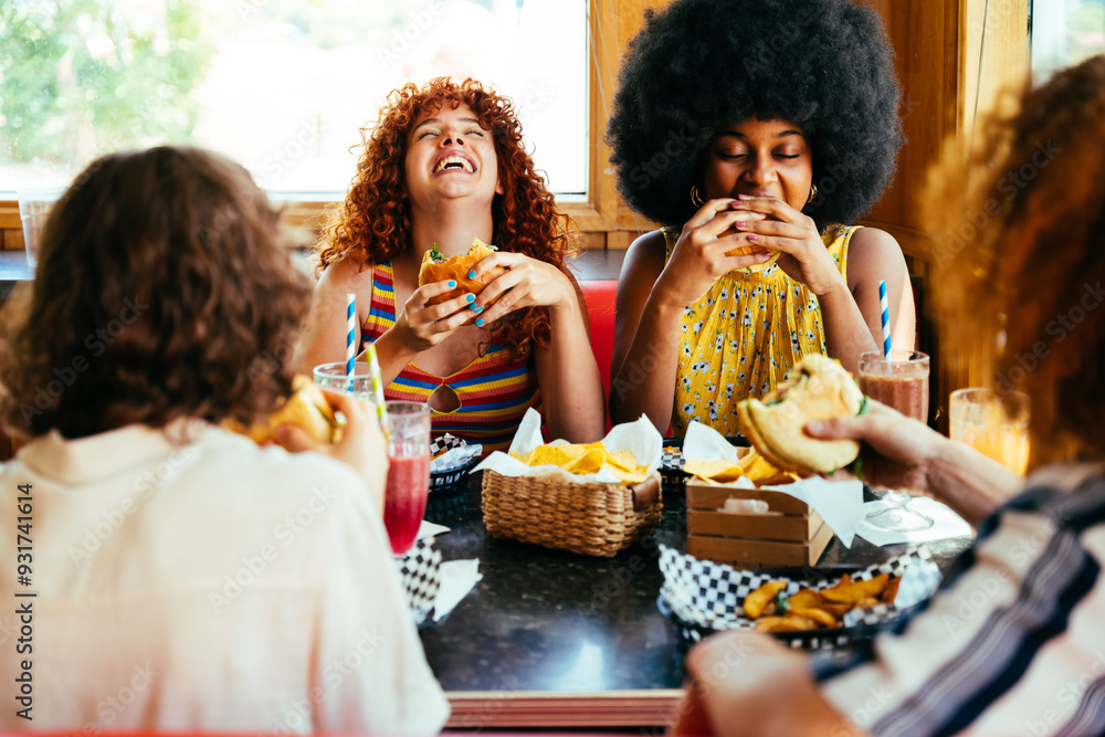 Multiethnic group of friends having meal at 80s vintage diner ...