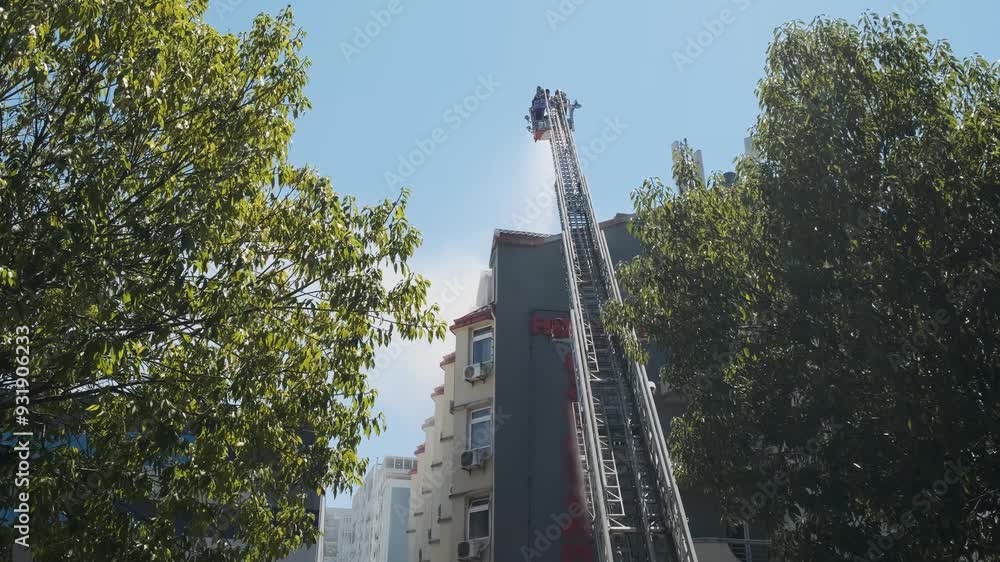 Back view of firefighters in elevated platform extinguish burning house ...