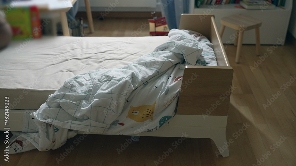 Child's unmade bed in a cozy bedroom, with blankets and pillows in ...