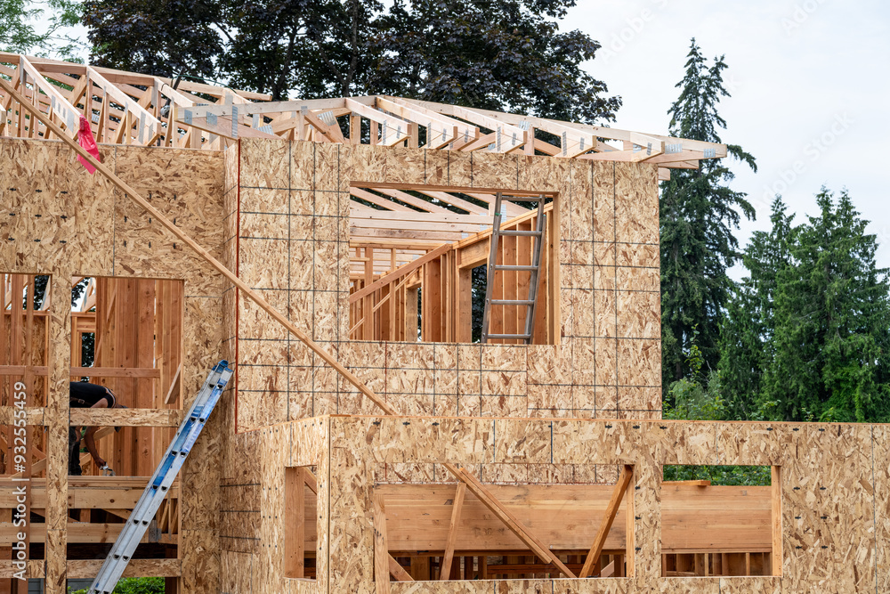 New residential home construction summer job site in framing stage, second floor started with ...