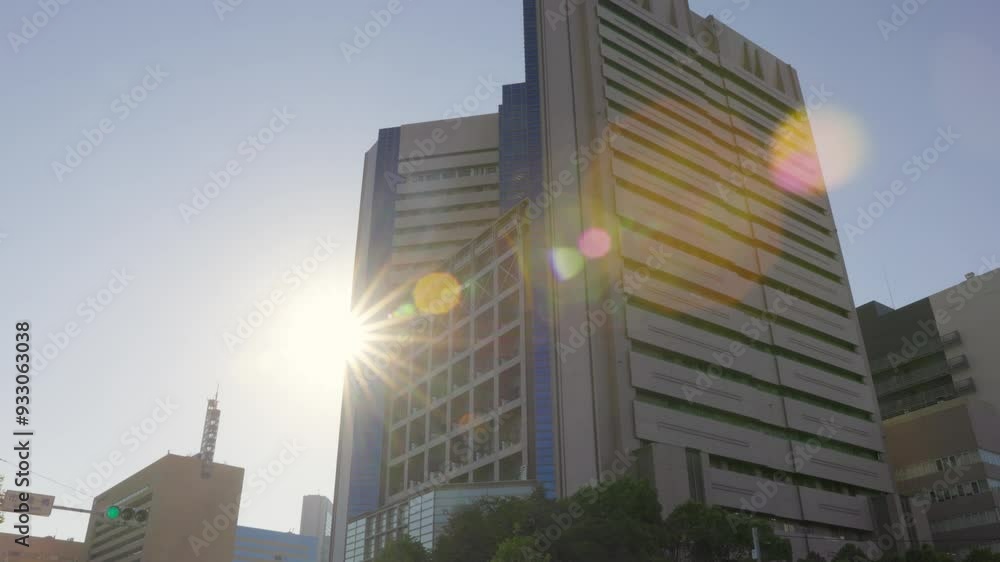 A tall hospital building in Tokyo stands against a clear blue sky with ...
