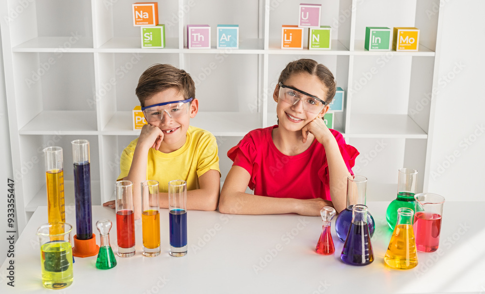 Two children wearing safety goggles conducting science experiments with ...
