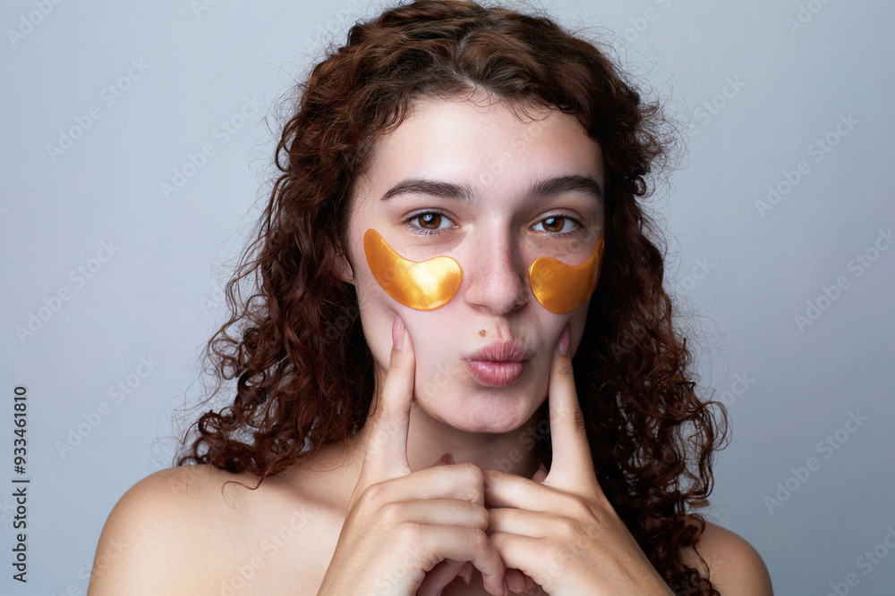 Young natural woman with pout lips pose and urly hair applying golden ...
