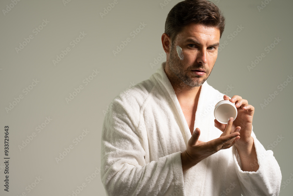 Beauty, skincare and man with cream on face using skincare products, lotion. Closeup of male ...