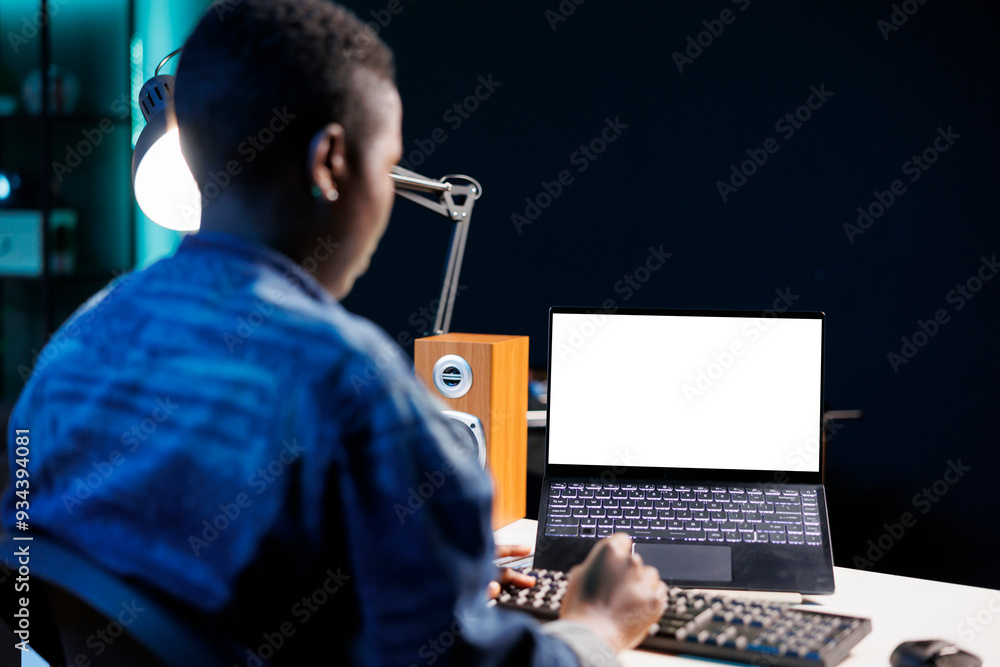 Black woman using a laptop displaying isolated white screen. African ...