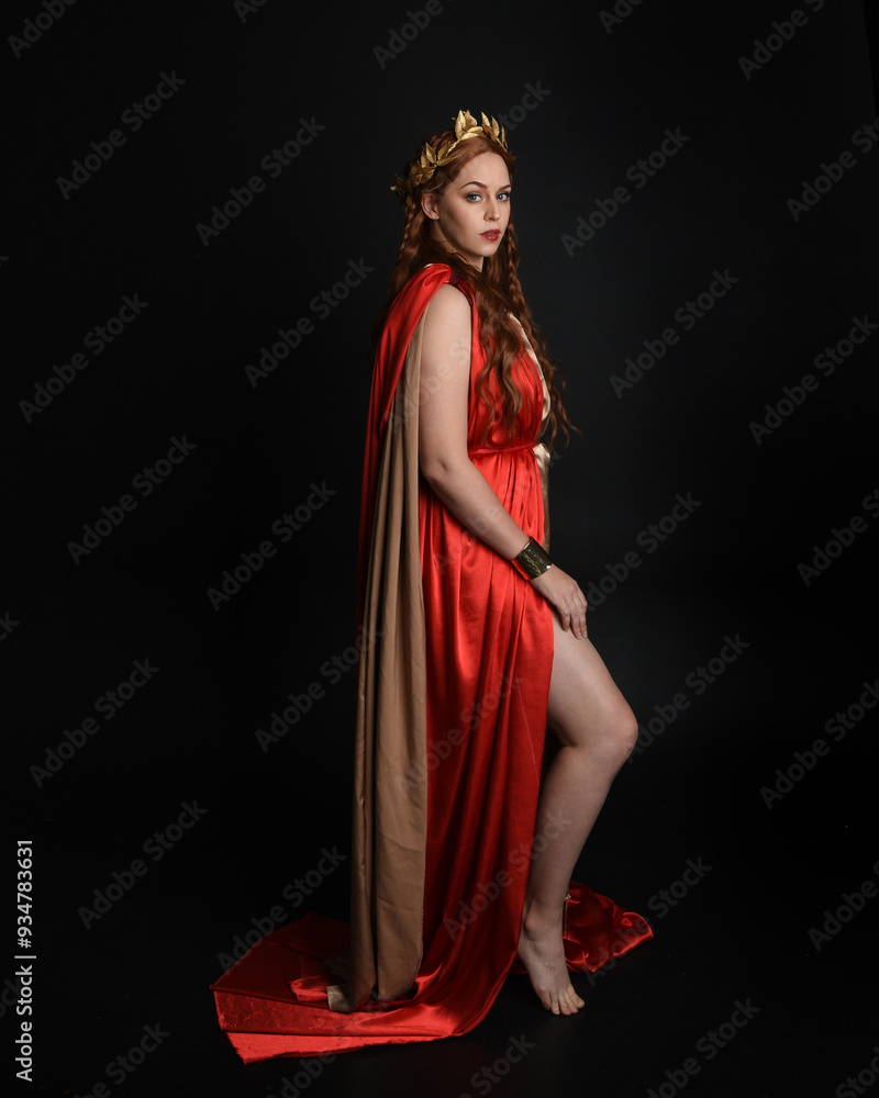Full length portrait of beautiful female model wearing grecian red silk ...