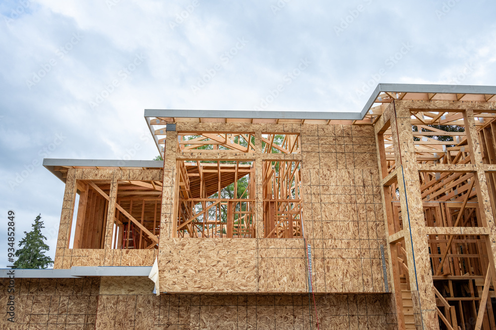 New large residential home construction in framing stage, with exterior ...