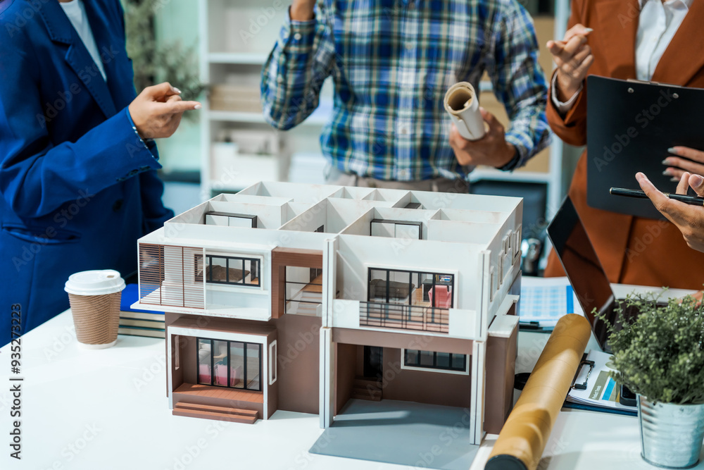 In an office room, architect-engineer team discusses modern house model ...