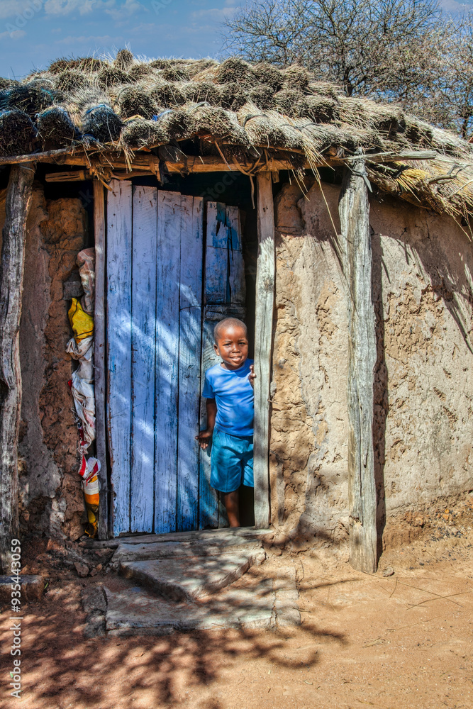 Single village african boy child standing in front of mud hut with ...
