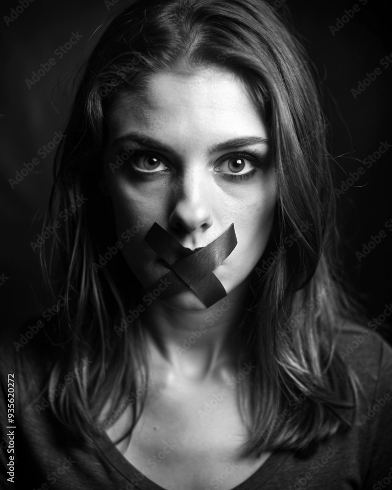 Portrait of a young woman with tape on her mouth. Black and white ...