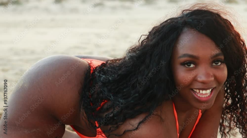 Happy overweight woman sitting on beach in swimsuit on sand dancing. Summer vacation concept of ...