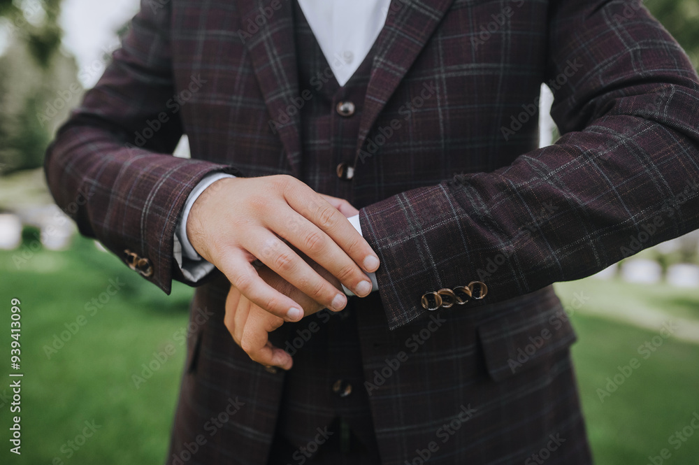 Stylish man in brown checkered suit, young businessman, groom buttoning ...