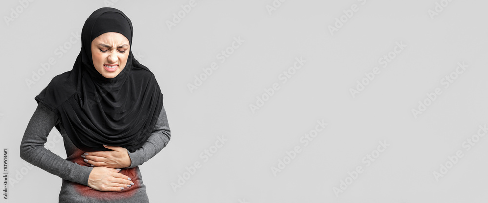 Menstrual cramps. Arabic woman in hijab suffering from acute abdominal ...