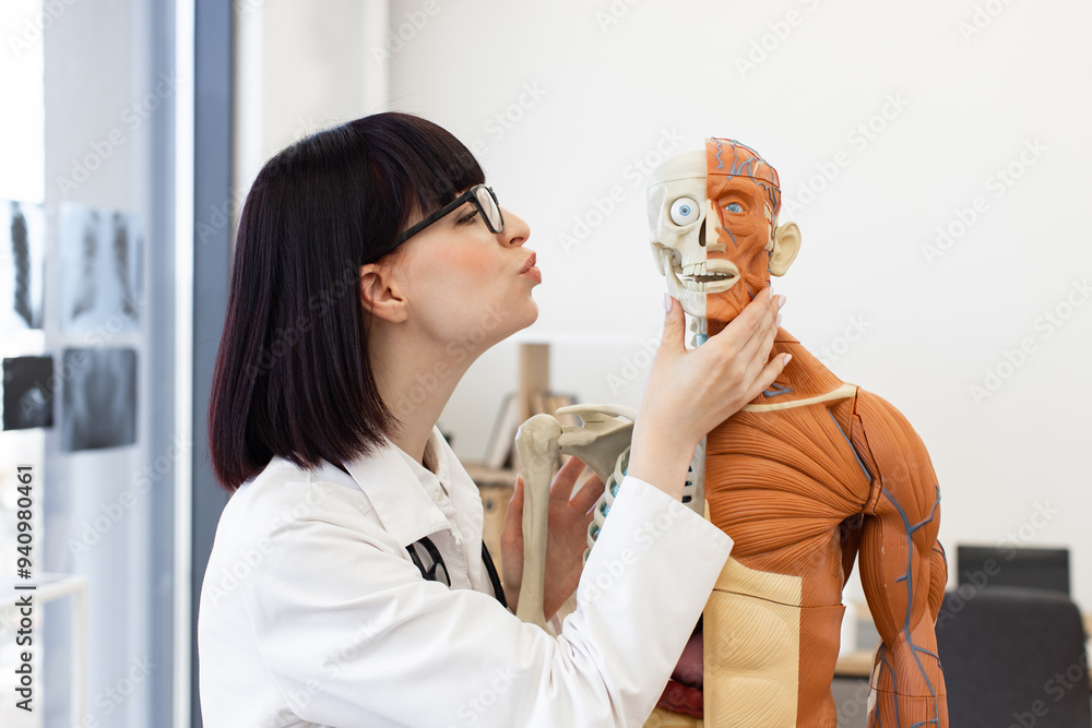 Medical student in white lab coat examining detailed anatomical ...
