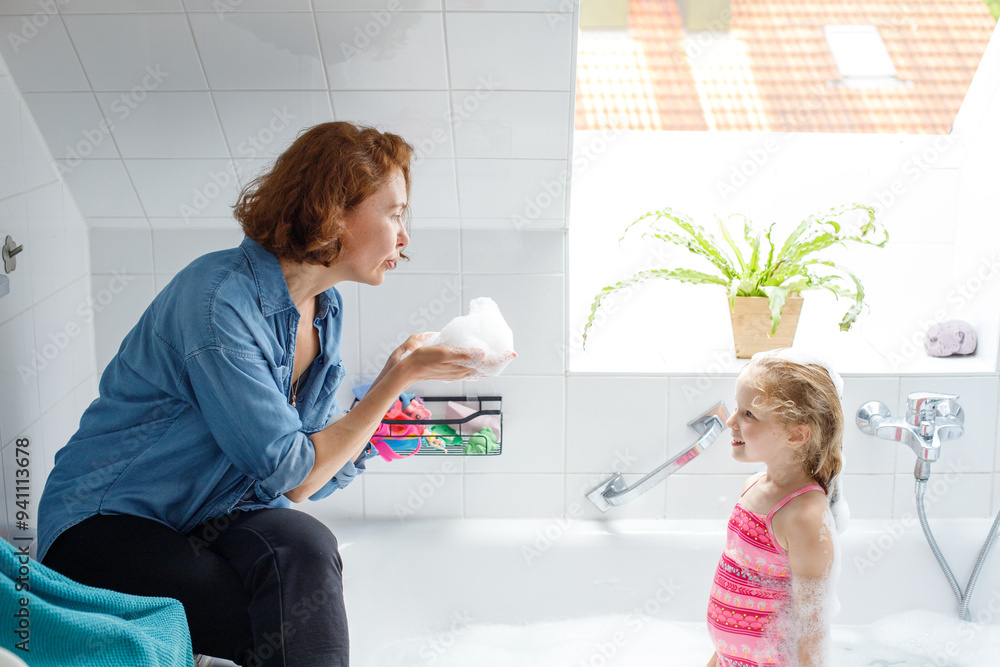 mother woman with little tween girl daughter having fun in the bath ...