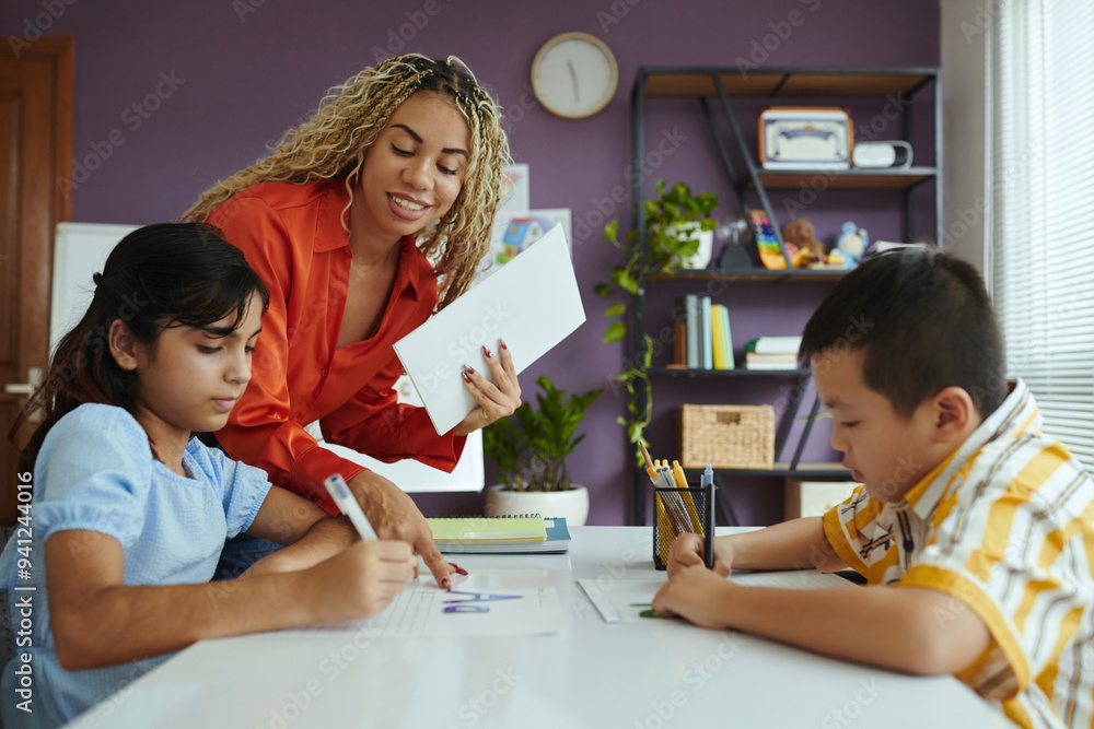 Diverse group of students receiving guidance from a smiling teacher in ...